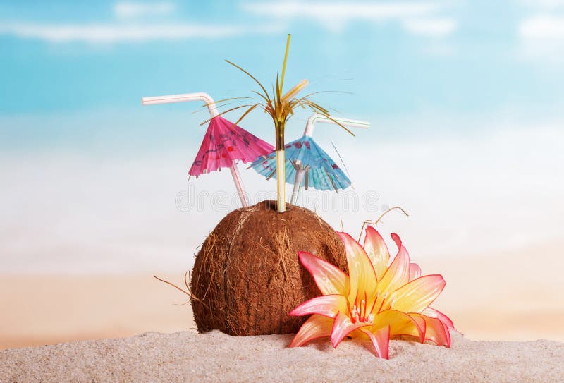 Coco Com Guarda-chuvas E Flor Da Palha Na Areia Contra O Mar Foto de ...