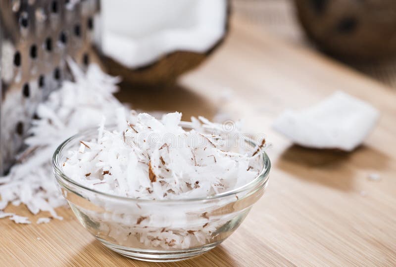 Coco Raspado Com a Cesta Do Branco Do Ralador E Da Porca Imagem de ...