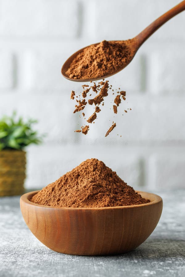 Cocoa Powder Falling from Spoon in Bowl on Table Stock Image - Image of ...
