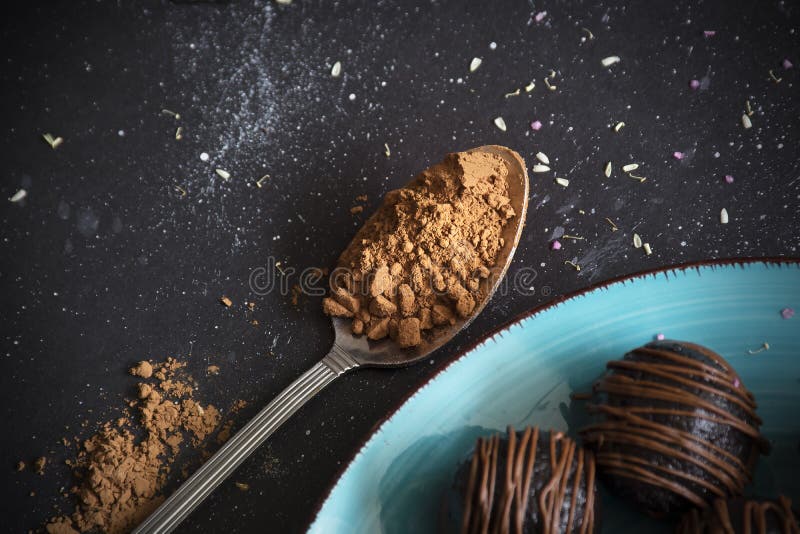 Cocoa Powder in Spoon, Chocolate Truffles on Blue Plate Stock Image ...