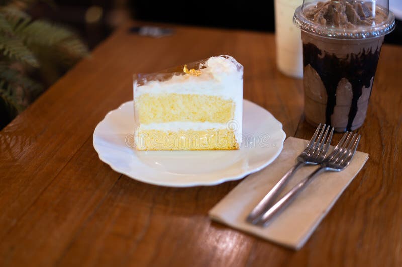 Coconut Cake on White Plate and Cold Drink on Wooden Table in Bakery or ...