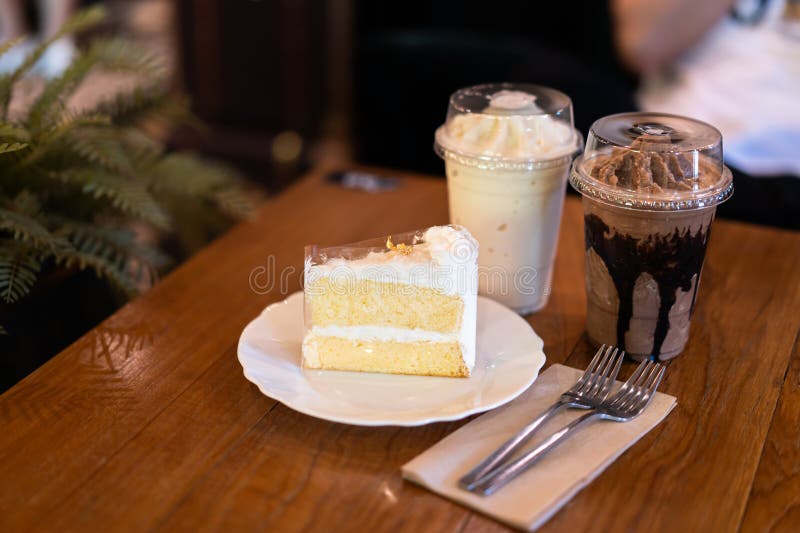 Coconut Cake on White Plate and Cold Drink on Wooden Table in Bakery or ...