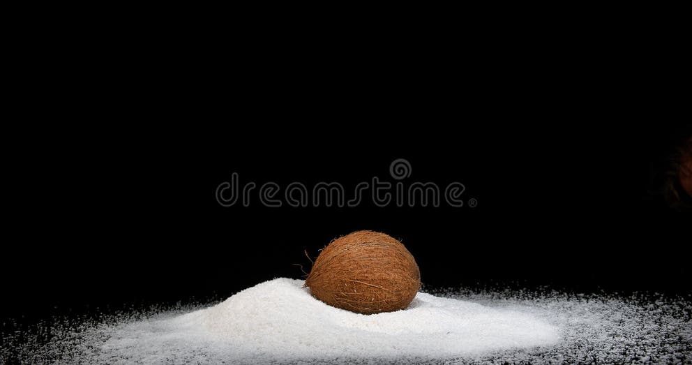Coconut, Cocos Nucifera, Fruit and Powder Exploding Against Black ...