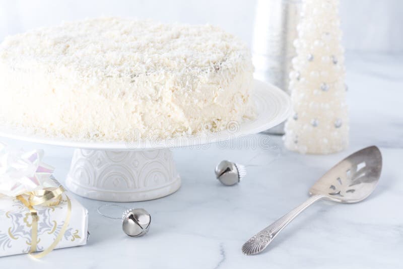 A Coconut Covered White Frosting Cake Surrounded by White Decorations ...