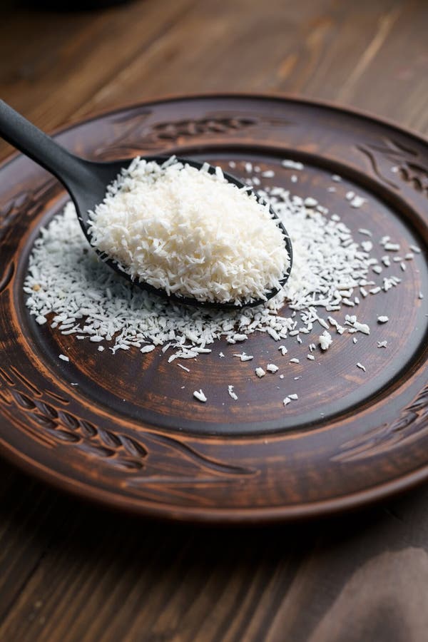 Coconut Flakes Separately, Raw on a Clay Plate and Spoon Stock Photo ...
