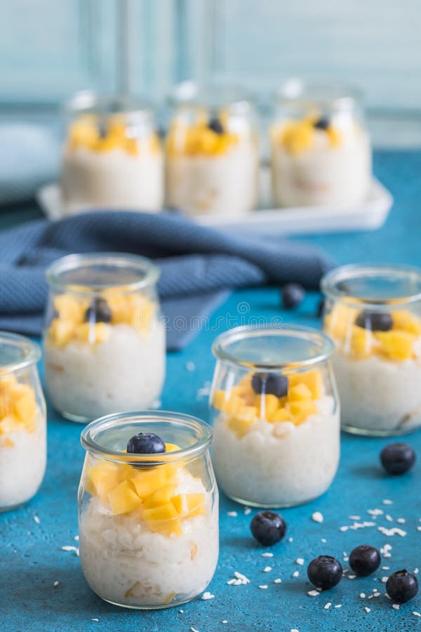 Coconut Rice Pudding with Mango in Dessert Glasses on Blue Background ...