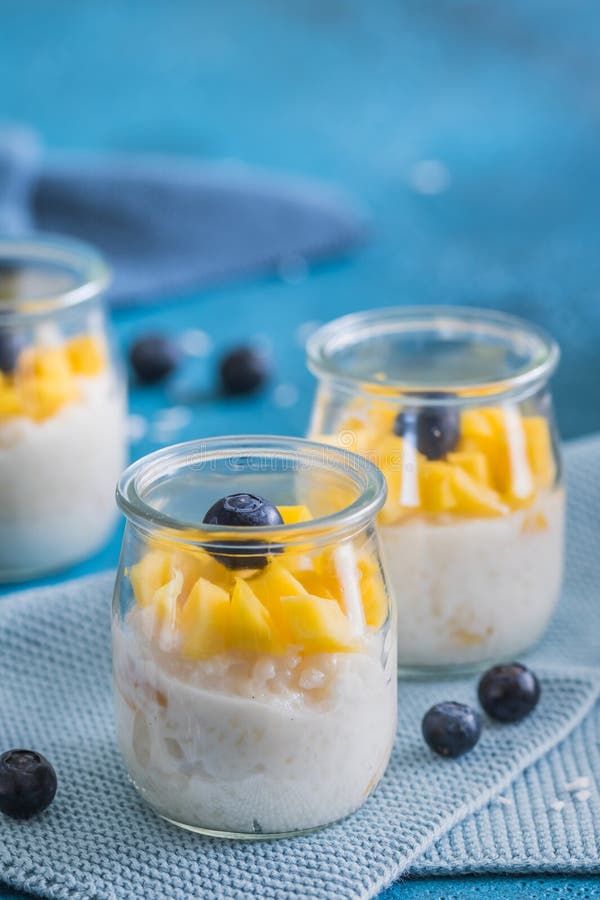 Coconut Rice Pudding with Mango in Dessert Glasses on Blue Background ...