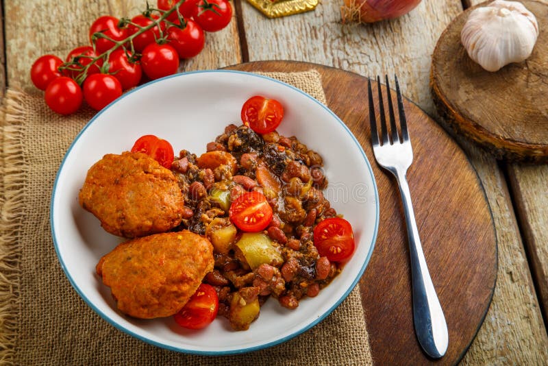 Cod Cutlets with Potatoes and Vegetables on a Round Stand Next To the ...