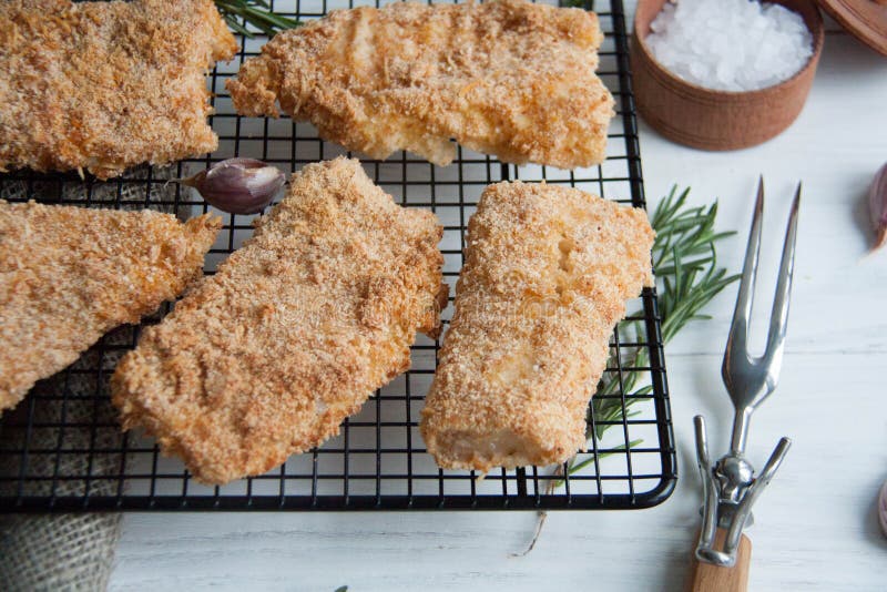 Cod Fish in Breadcrumbs on a Black Wire Rack Stock Photo - Image of ...