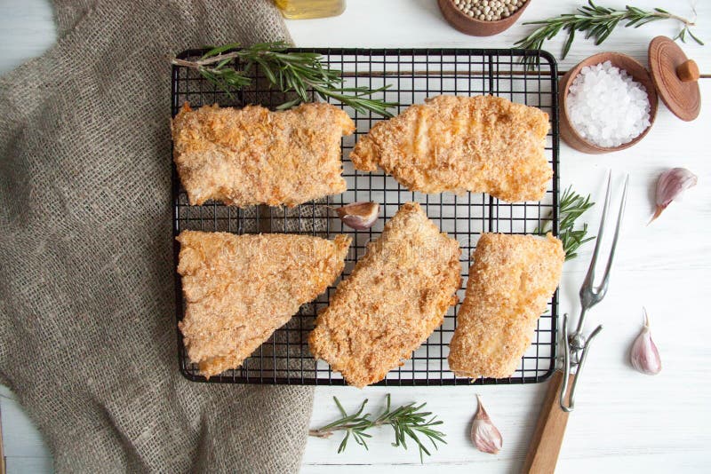 Cod Fish in Breadcrumbs on a Black Wire Rack Stock Photo - Image of ...