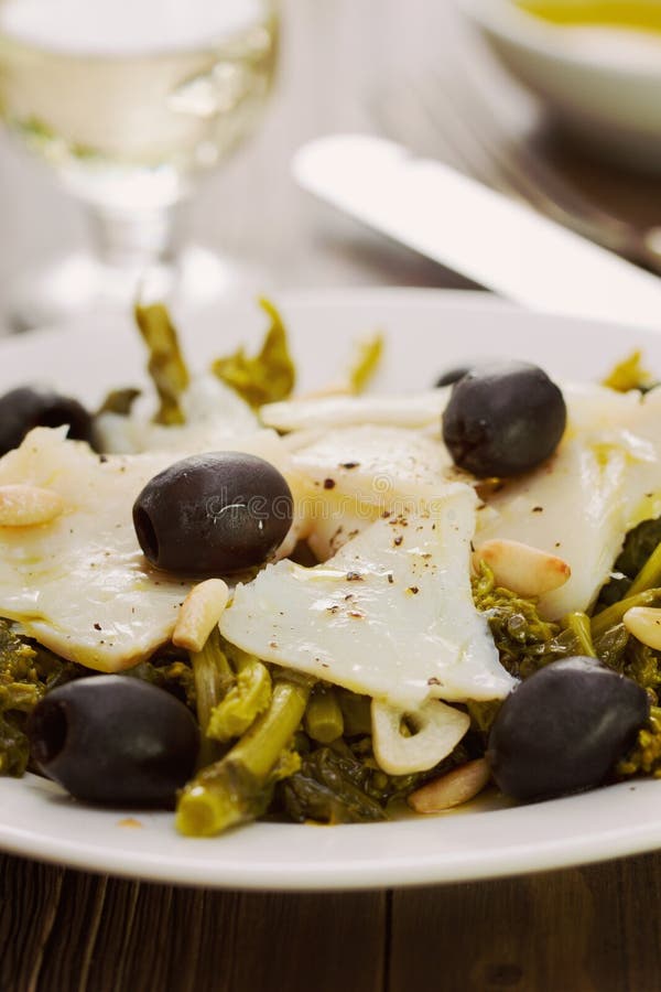 Cod Fish with Olives and Greens on White Plate Stock Image - Image of ...