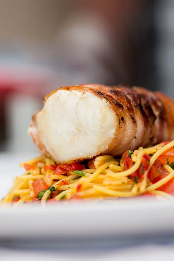 Cod wrapped in bacon stock photo. Image of basil, tomato - 43211356