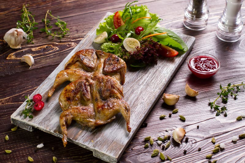 Codornices De La Carne Asada Con La Ensalada Vegetal Foto de archivo ...