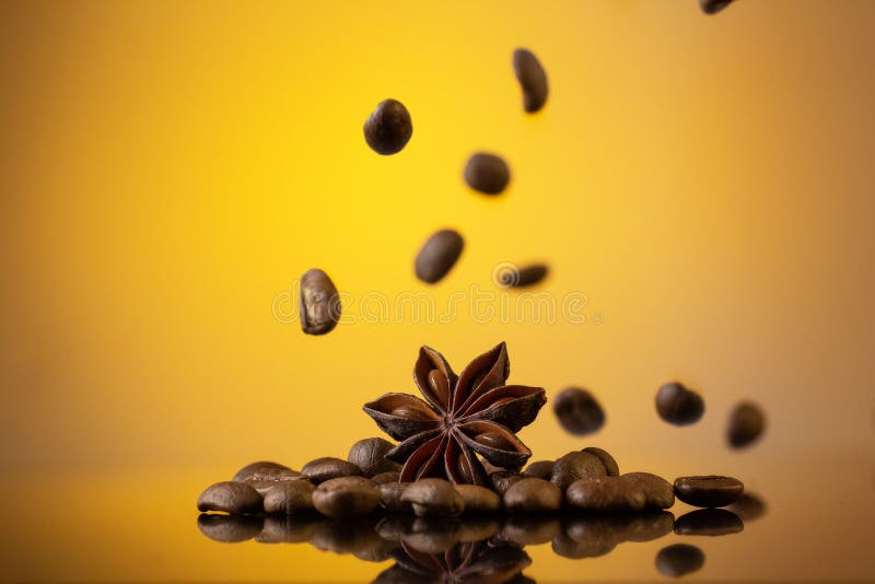 Coffee Beans Falling Around Star Anise on a Reflective Surface with a ...