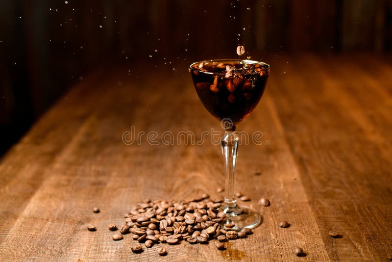 Coffee Beans Falling in Alcohol Cocktail on Table Stock Image - Image ...