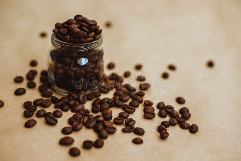 Coffee Beans in a Glass Jar. Dark-colored Roasted Coffee Beans on Kraft ...