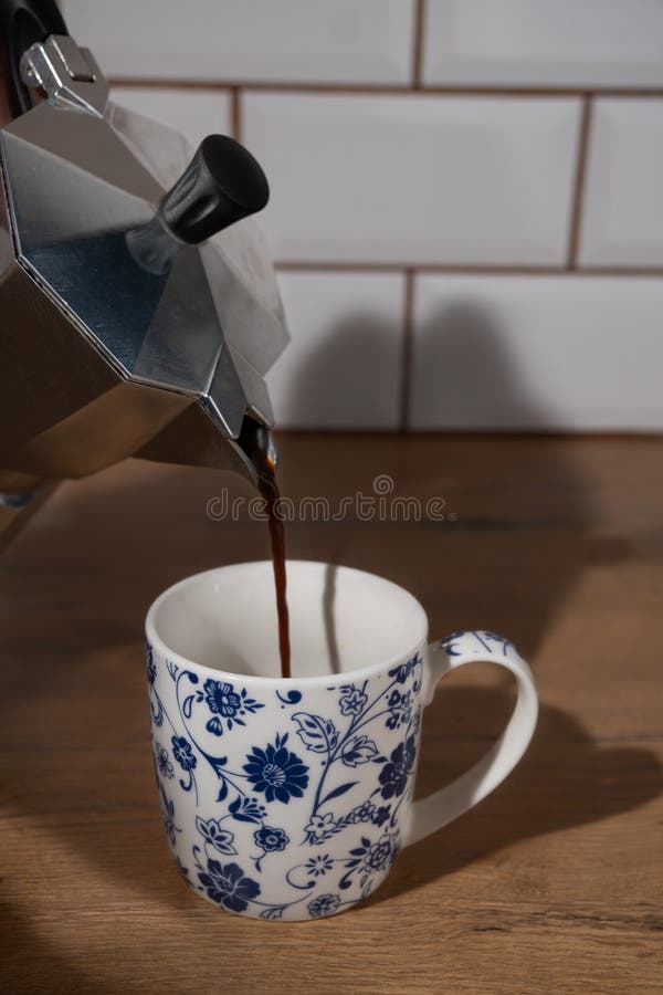 Black Coffee Being Poured into a Blue and White Cup Stock Photo - Image ...