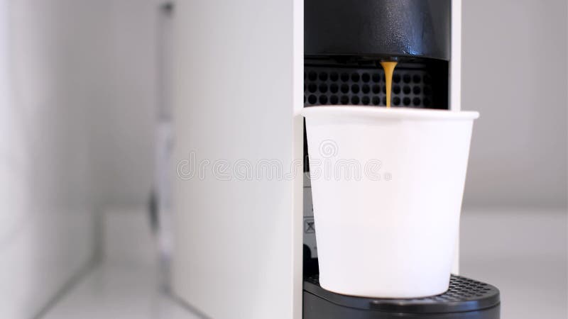 Coffee from a Capsule Coffee Machine is Poured into White Paper Cup ...