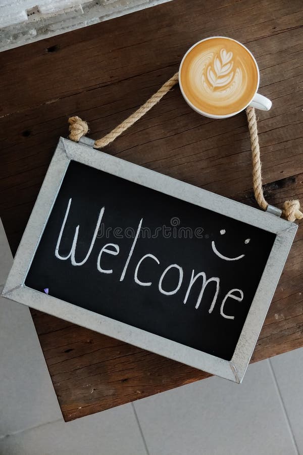 Coffee Cup with Latte Art and the Welcome Sign on Wood Table Stock ...