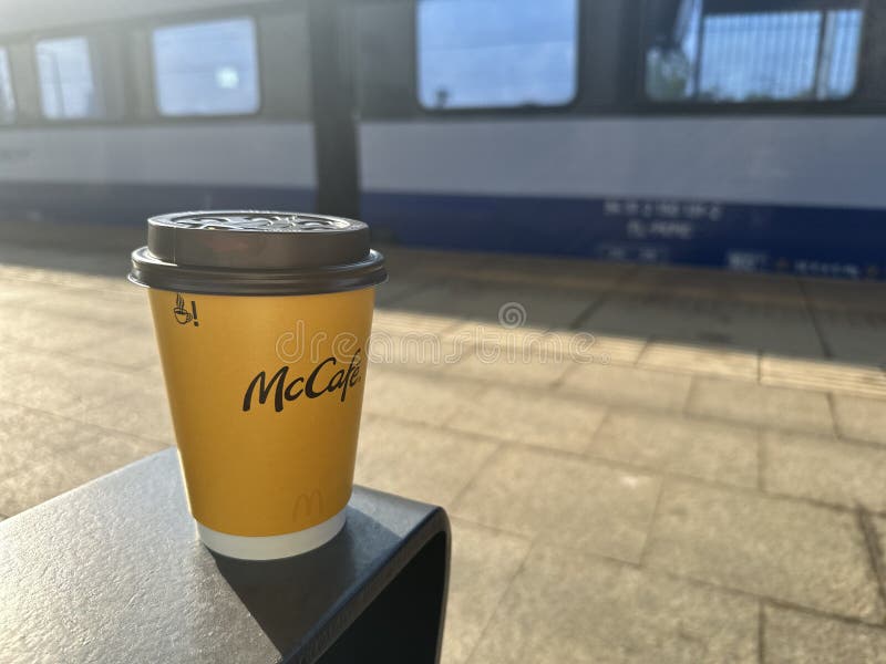 Coffee Cup Placed on a Table at a Train Station, with a Blurred Train ...