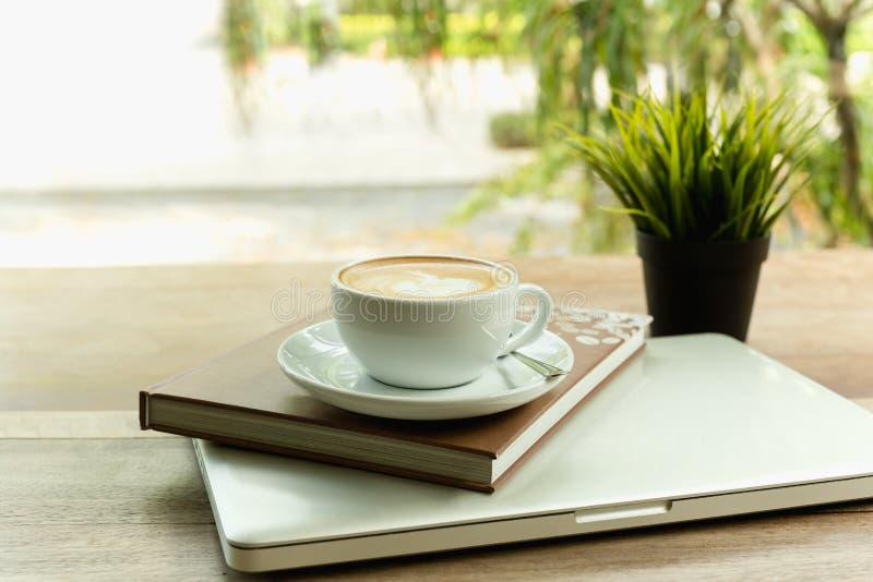 Coffee Cup on Top of Book and Laptop Computer on Wooden Table in Cafe ...