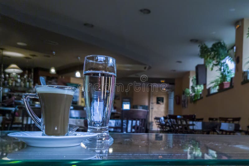 Coffee Cut with Milk, Along with a Glass of Fresh Water. Stock Photo ...