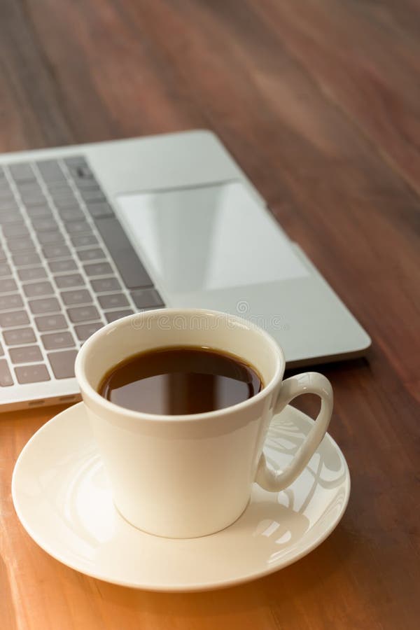 Coffee Served in a Cup, Placed beside a Portable Computer Stock Photo ...