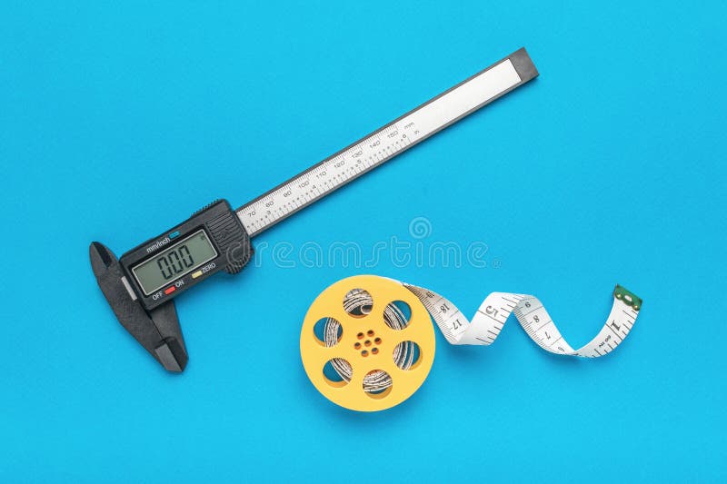 A Coil with a Measuring Tape and a Caliper on a Blue Background Stock ...