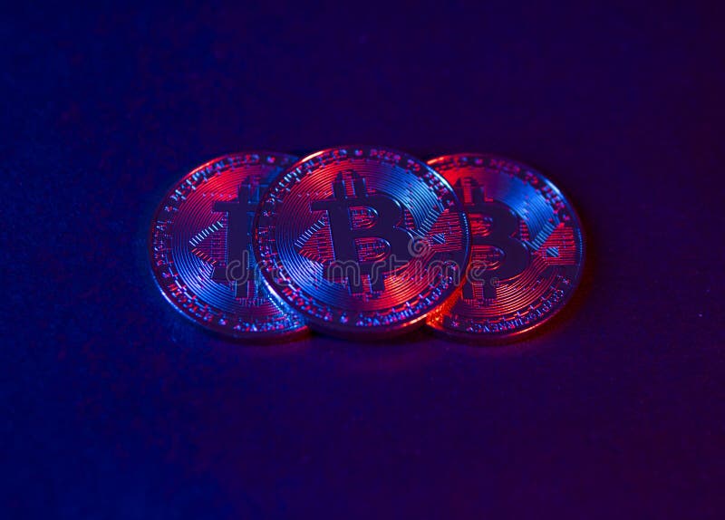 The Coins of Bitcoin are on a Dark Surface. Purple and Pink Neon Light ...