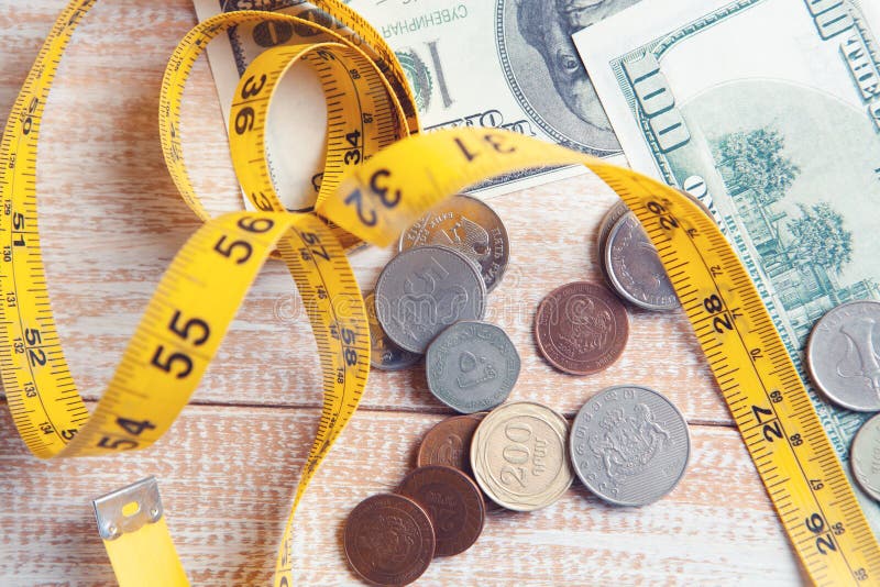 Coins, Dollar Bills and Measuring Tape on the Table Stock Image - Image ...