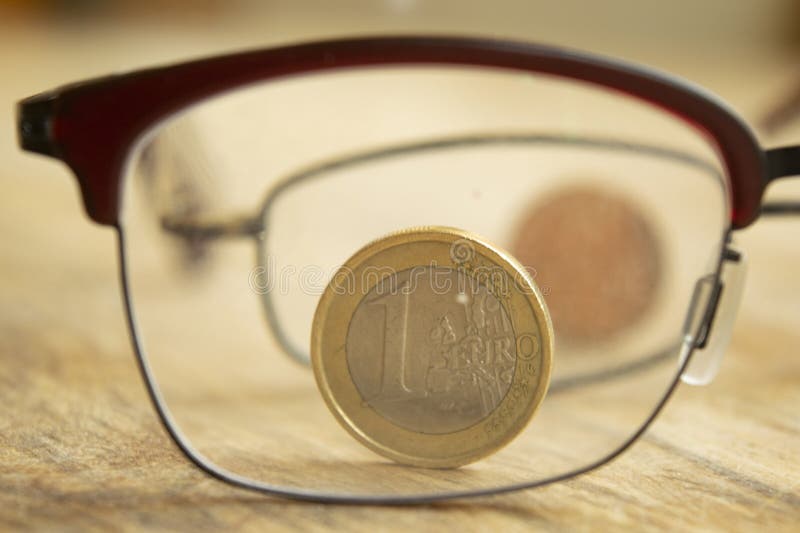 Coins Seen through the Lens of an Eyeglass Stock Image - Image of ...