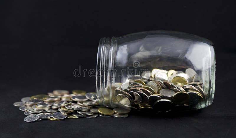 Coins Spilling from a Jar stock image. Image of wealthy - 30621453