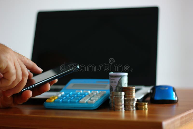 Coins Stack on Wood Table while Worker Using Mobile Phone Searching ...
