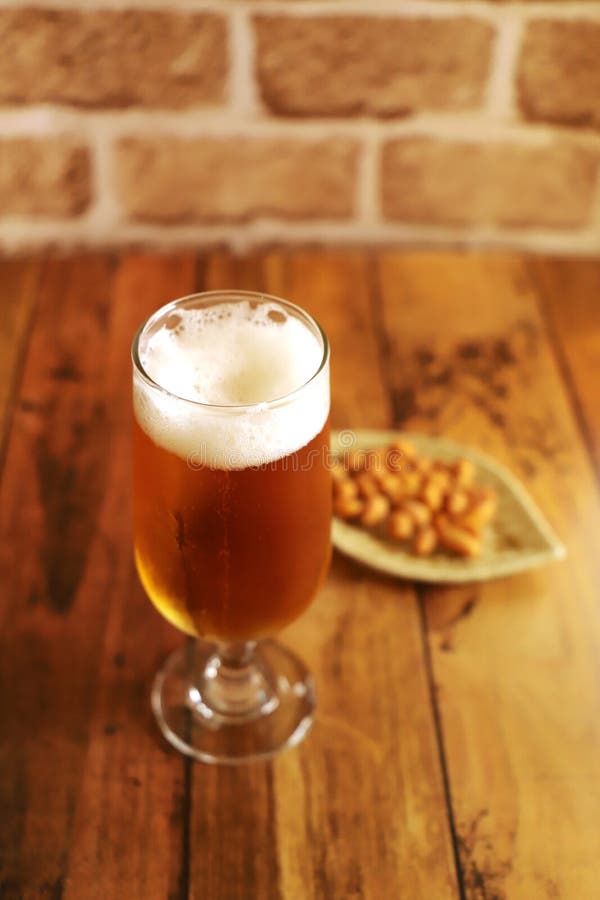 Cold Beer Poured into a Glass and Snack Nuts Stock Photo - Image of ...