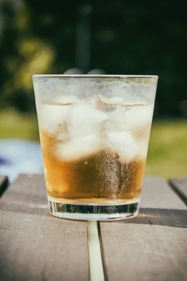 Cold Drink with Ice Cubes on a Wooden Table Stock Image - Image of ...