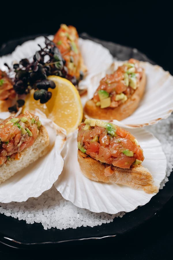 Cold Fish Appetizer in Shells on a Black Background Stock Image - Image ...