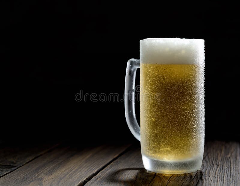 Cold Frothy Beer in a Glass on a Dark Wooden Background Stock Image ...