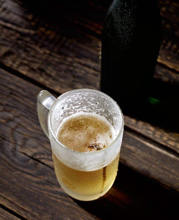 Cold Frothy Beer in Glass on a Wooden Background Stock Photo - Image of ...