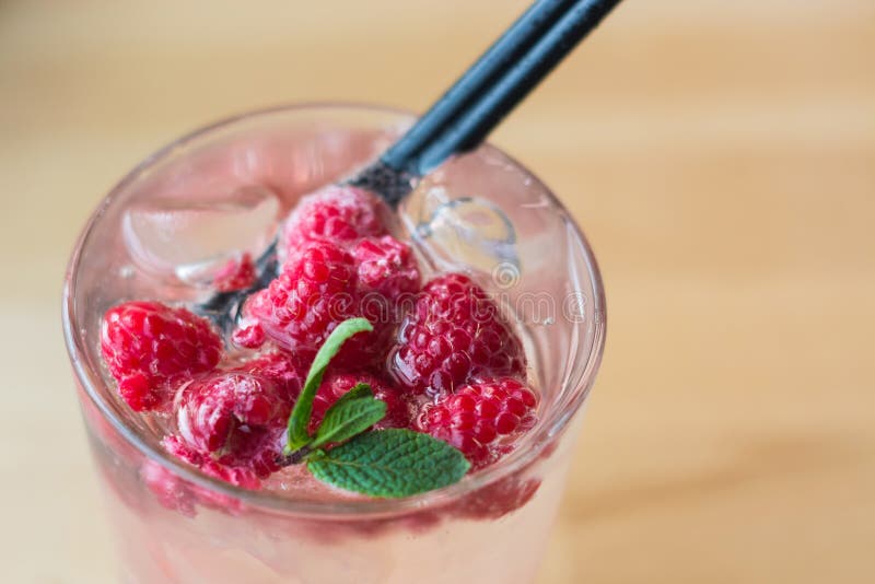 Cold Raspberry Drink with Mint Leaves in a Sweaty Glass on a Table in a ...