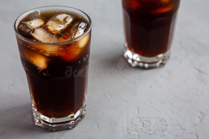 Cold Refreshing Dark Cola with Ice Cubes, Straws on a Gray Surface ...