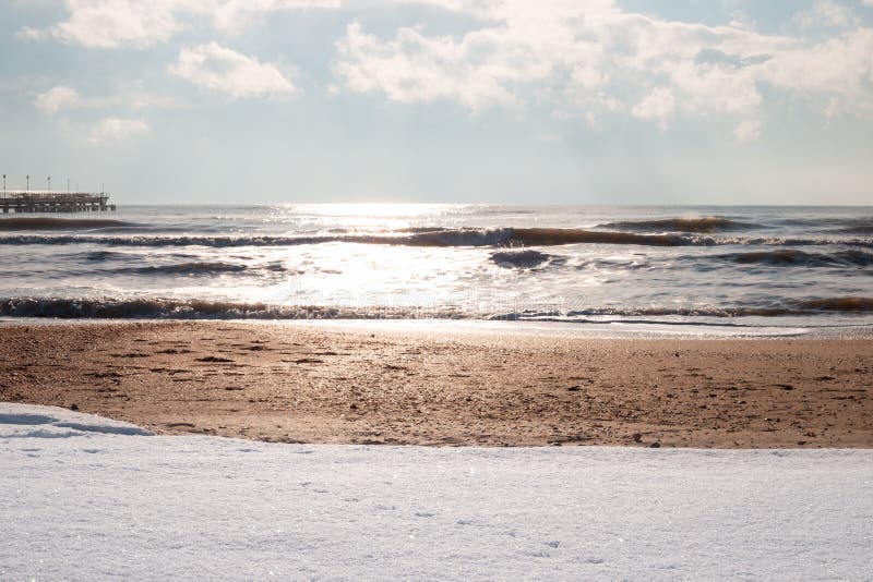 Cold Sea with a Pier and Snow on the Sandy Shore. Black Sea in Winter ...