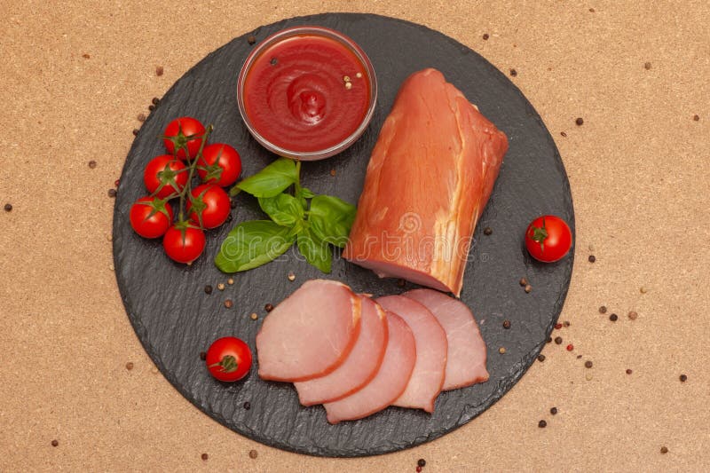 Cold Smoked Meat with Sauce, Cherry Tomatoes and Basil on a Black ...