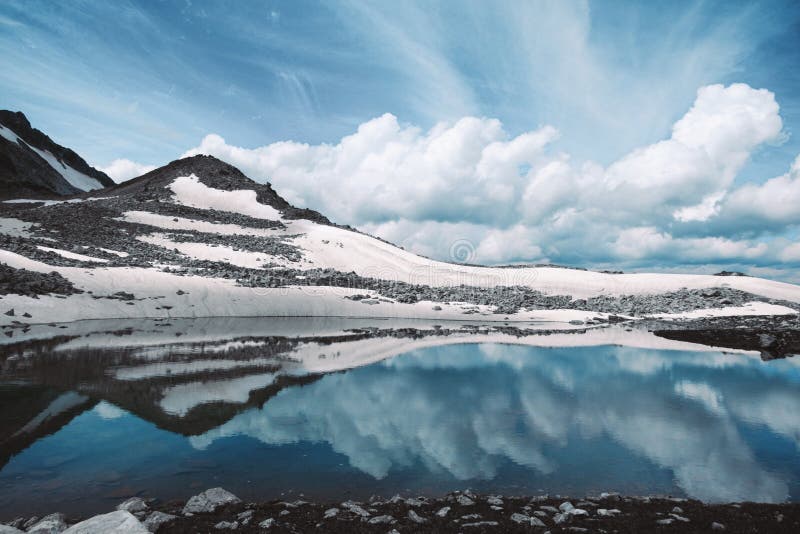Cold Snowy Lake with Water Mirror Reflection of Clouds and Mountains ...