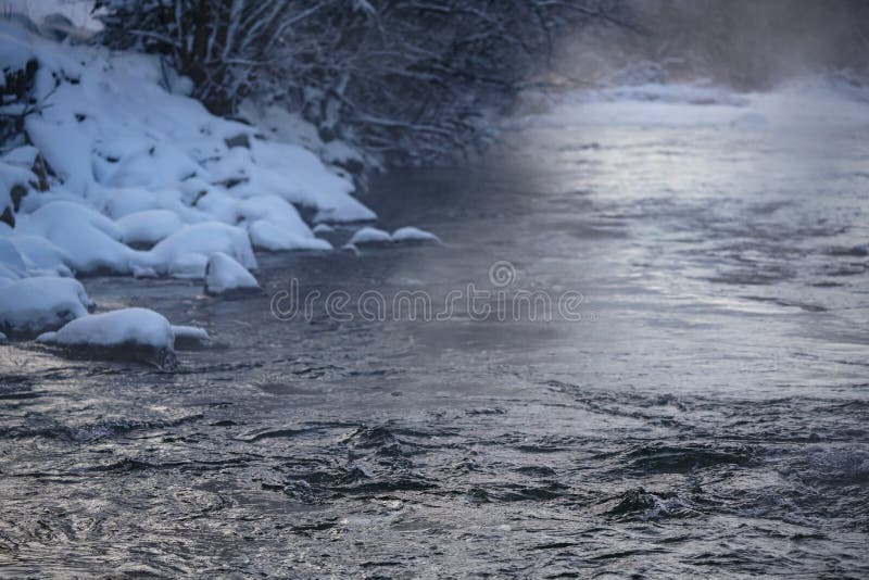 Cold Winter River, Steam Visible Above Water, Dark Trees on Both Sides ...