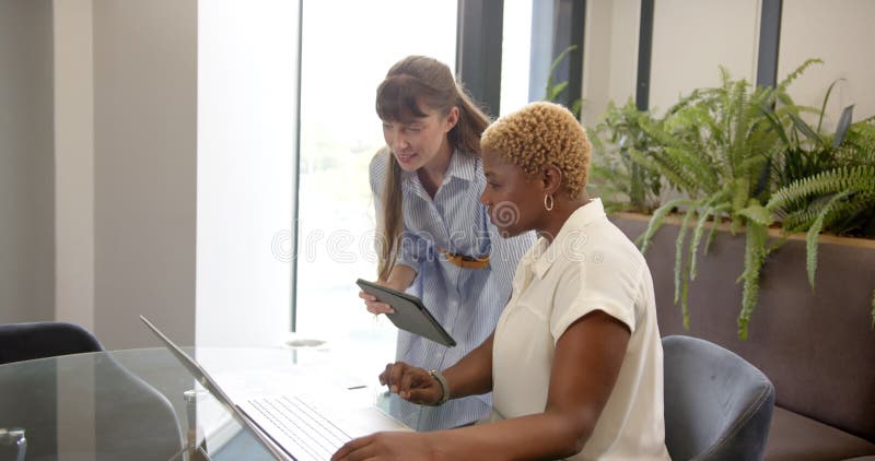 Collaborating on Project, Two Women Using Laptop and Tablet in Office ...