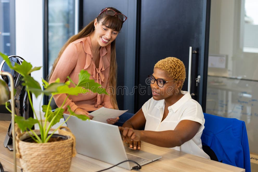 Collaborating at Work, Two Women Using Laptop and Discussing Document in Office Stock Image ...