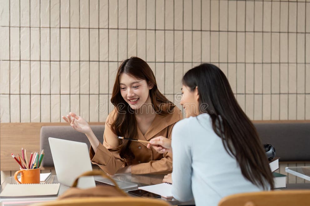 Collaboration and Creativity. Two Students Share Ideas and Knowledge while Using a Laptop in a ...