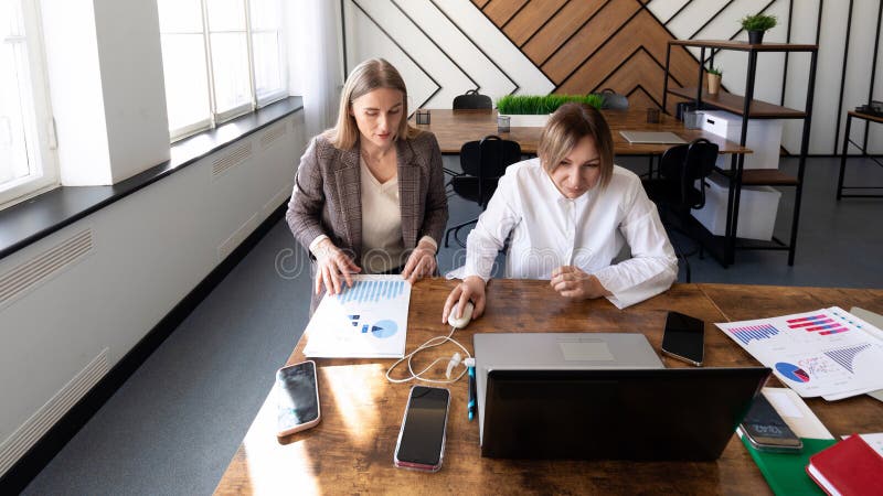 Collaboration between Two Women Analyzing Data and Discussing Project ...