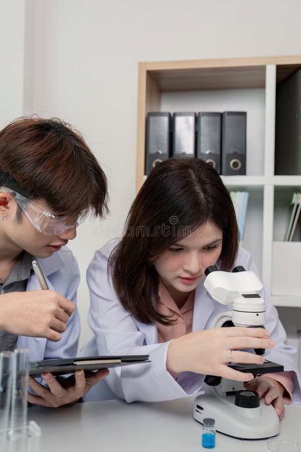 Collaborative Scientific Team Conducting Microscopic Analysis in Lab ...