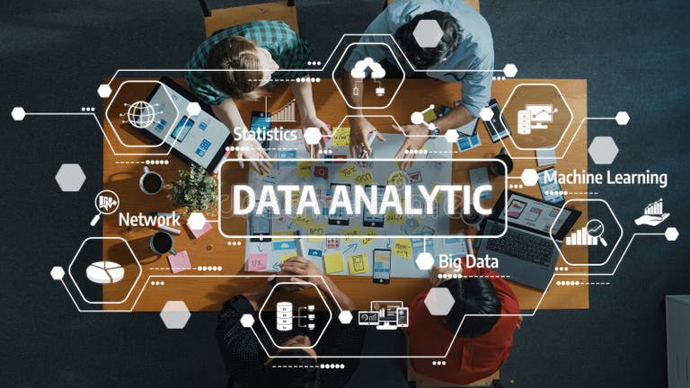 Collaborative Team Working on Data Analytic Project with Technology Icons and Charts on Table ...
